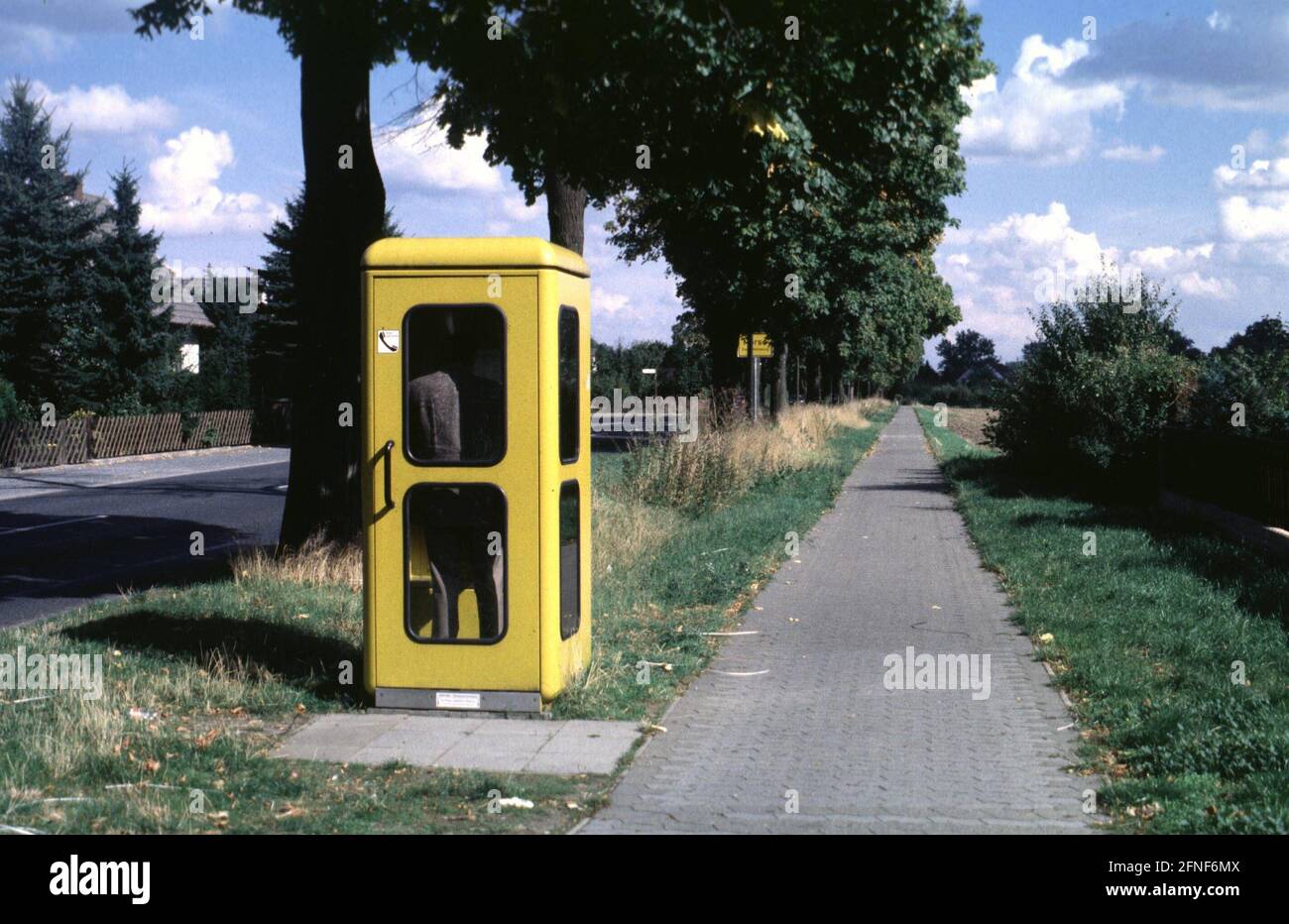 Yellow telephone box of Deutsche Telekom in the countryside of Lower ...