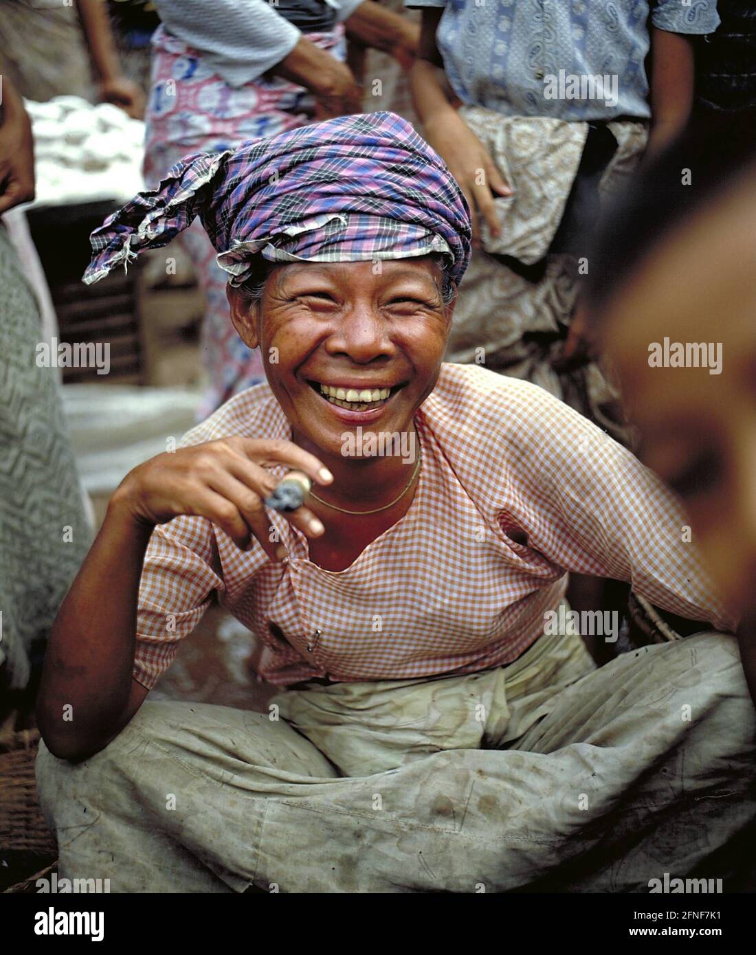 Market woman in an inland village. The hash cigar is rolled with ...