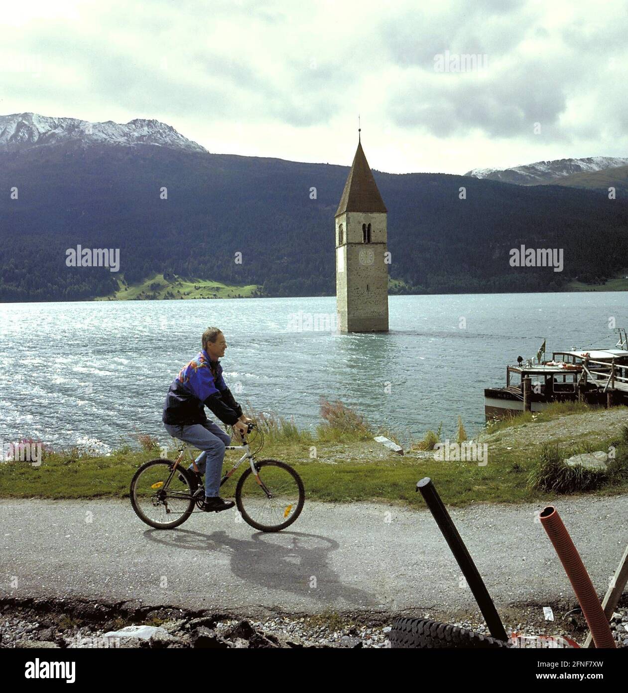 The spire of the sunken church of Graun rises out of the Reschensee ...
