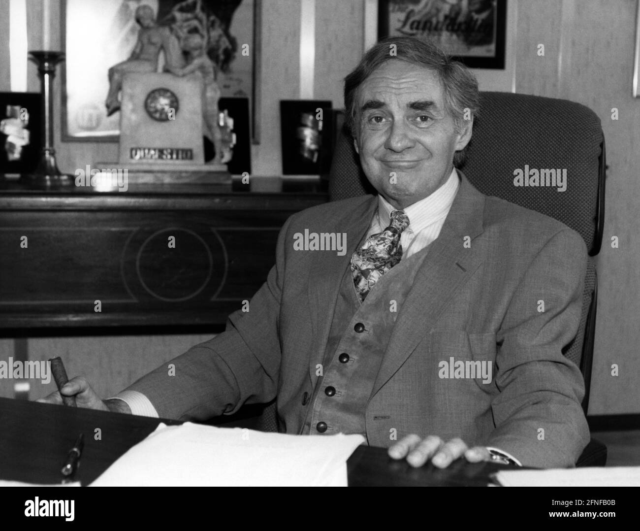 Harald Juhnke at his desk with a cigar in his hand. [automated ...