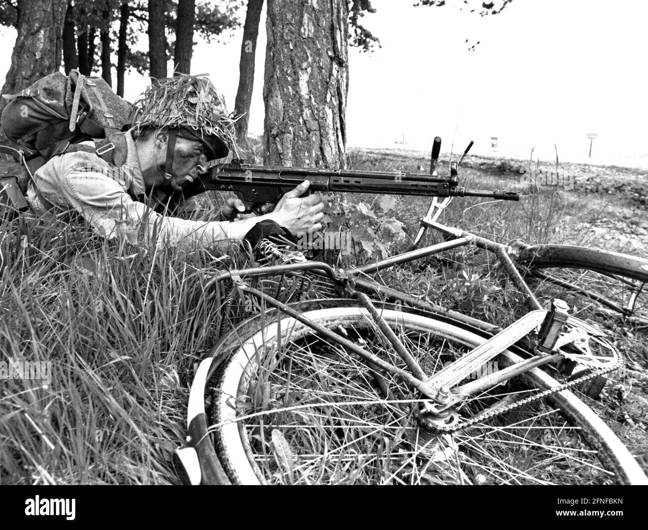 A soldier lies in position with his G3. The soldier is taking part in ...