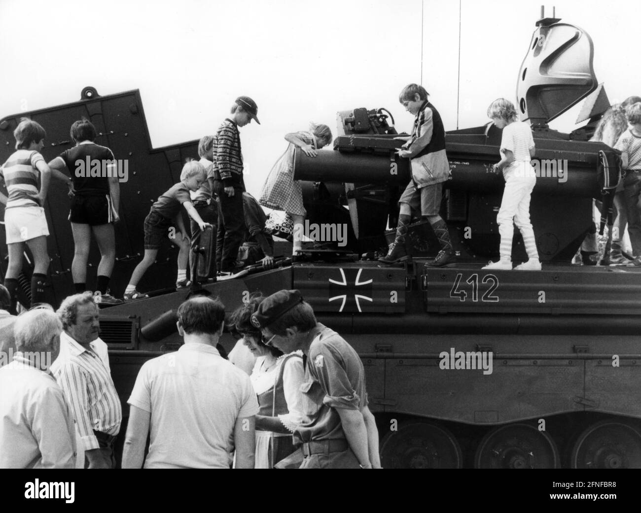 Soldiers demonstrate weapons and equipment to civilians. Here an ...