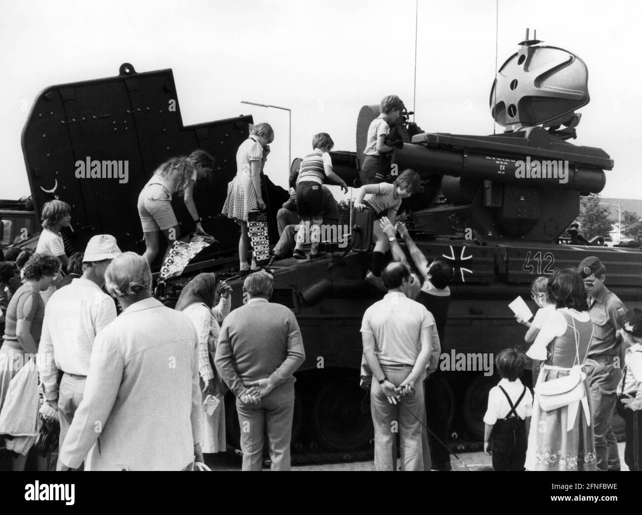 Soldiers demonstrate weapons and equipment to civilians. Here an ...