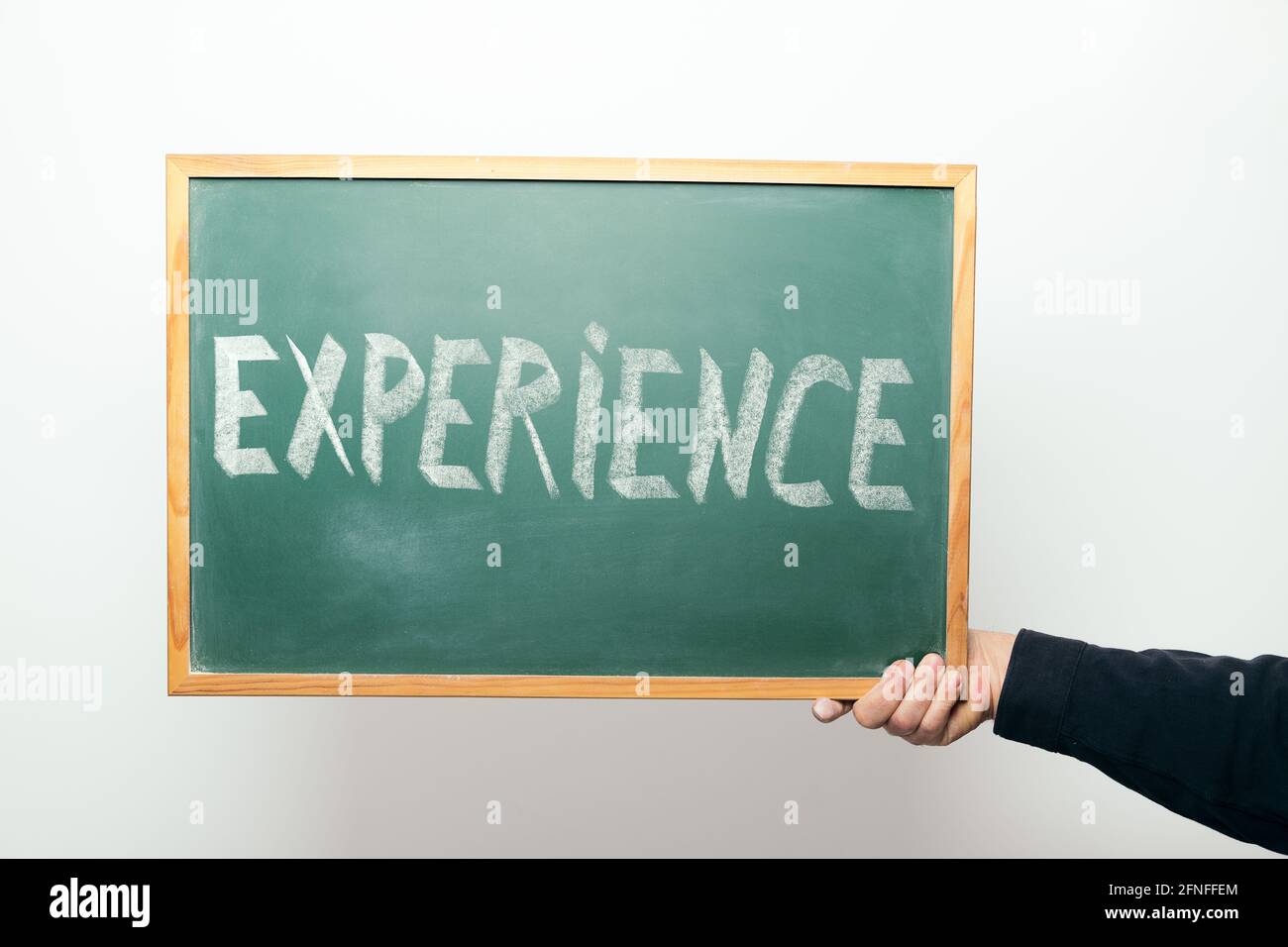hand holding a chalkboard with the word EXPERIENCE handwritten in chalk ...