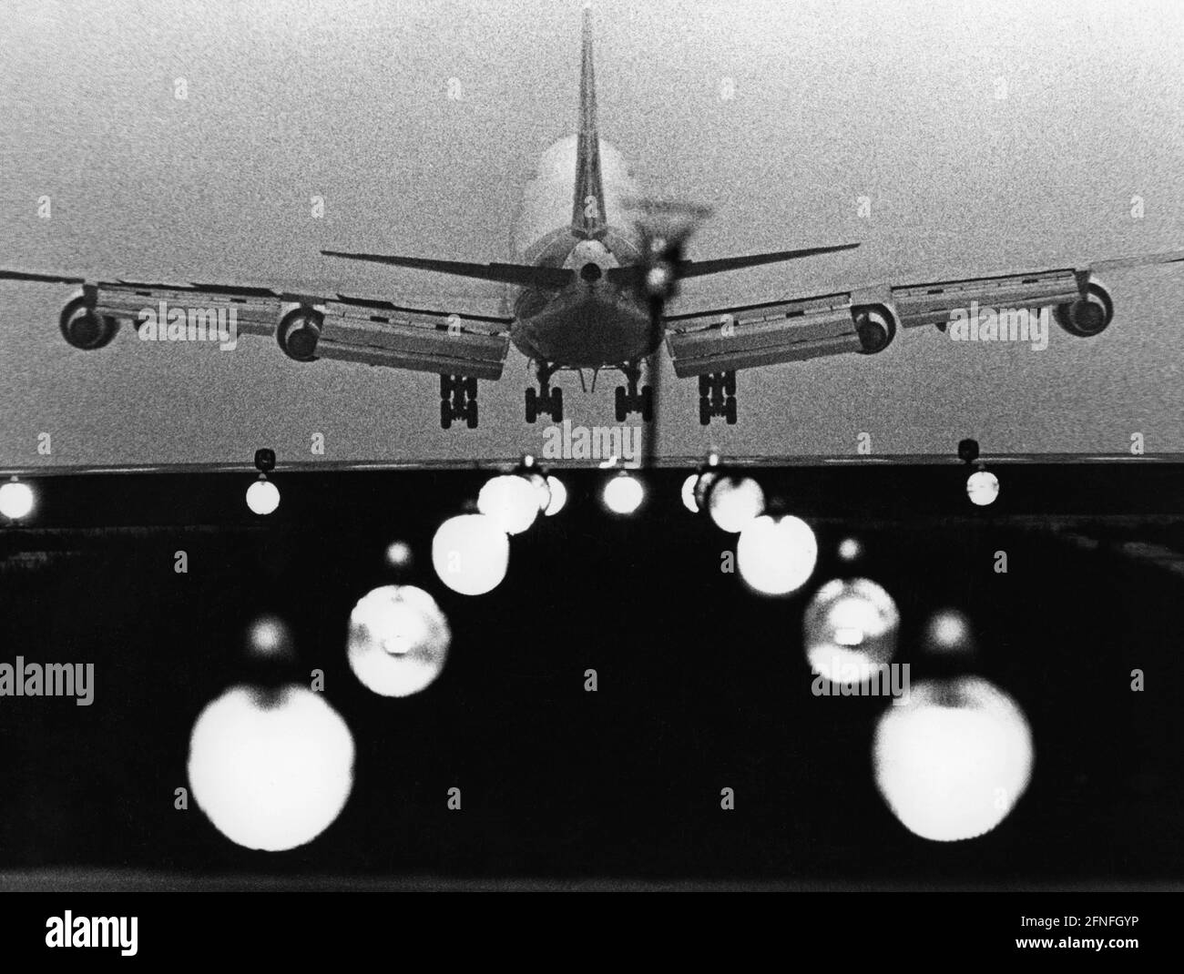 A Boeing 747 during landing. The runway lights are clearly visible ...