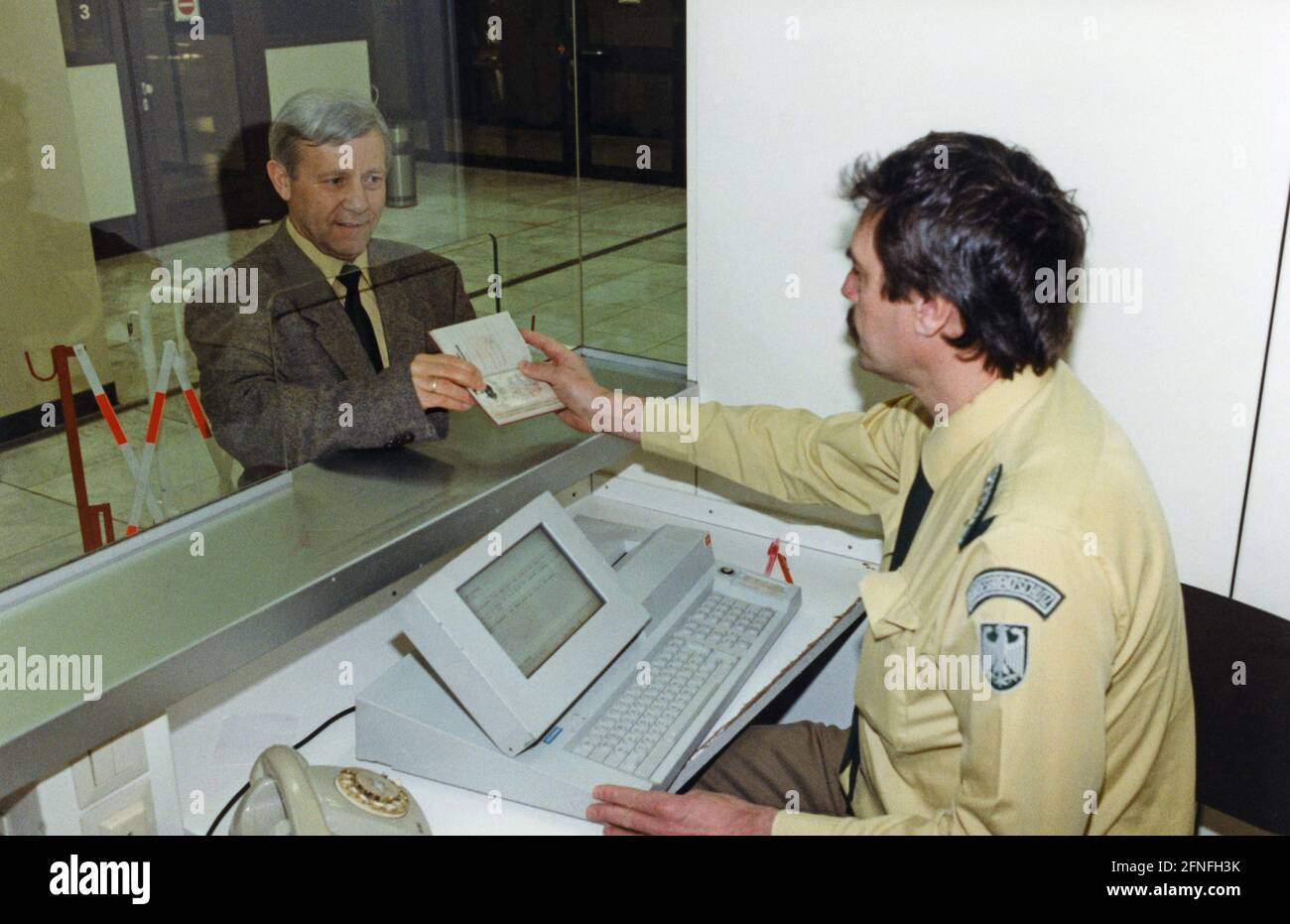 An officer of the Federal Border Guard checks the passports of the ...