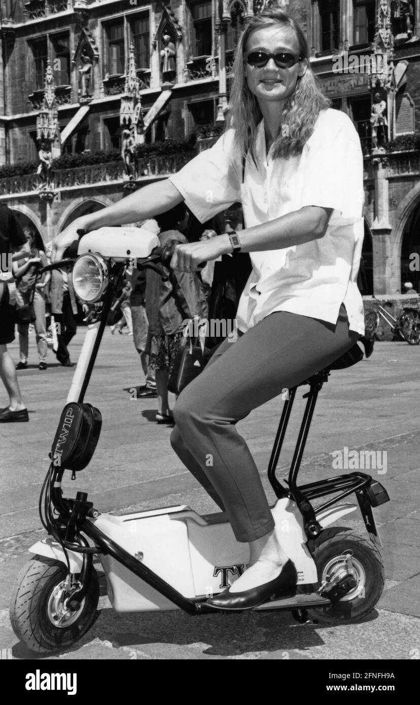 A woman sits on a Twip, the first approved electric scooter in Germany ...