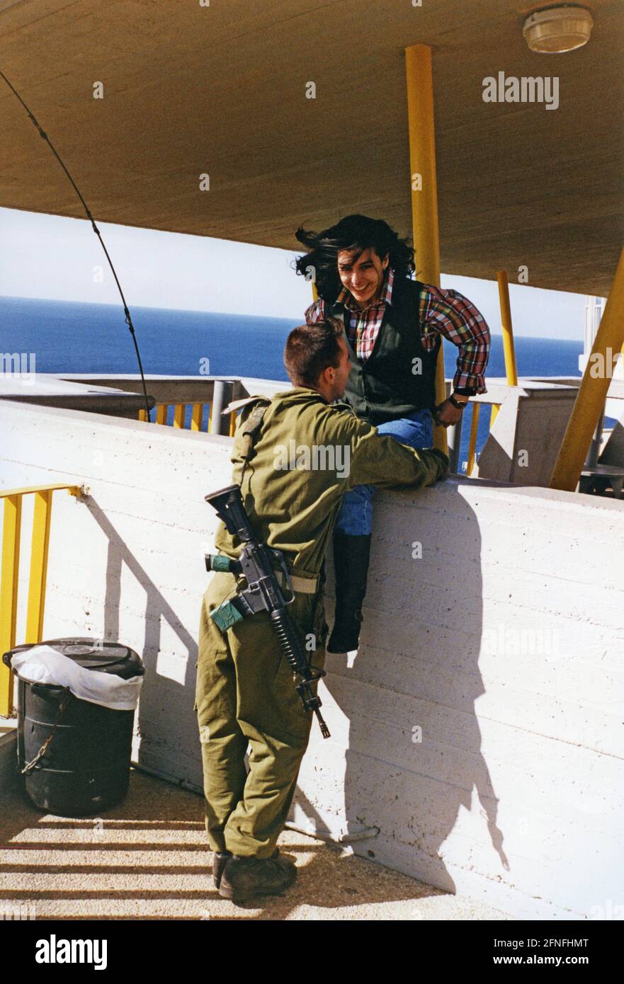 An Israeli border guard hugs a young woman at a border crossing with ...