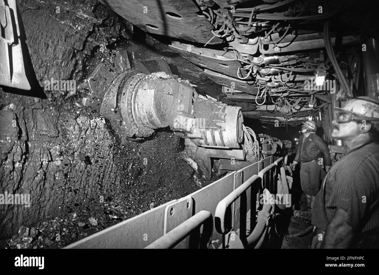 Two miners watch a working coal plough at the coal seam in Zollverein ...
