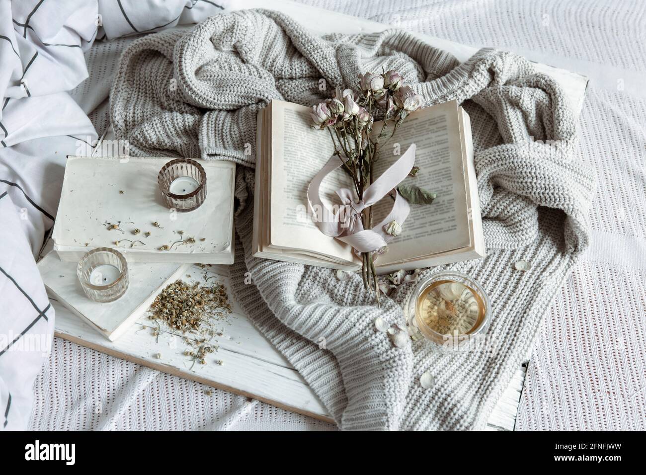 Cozy spring still life with candles, tea, teapot and decorative details ...