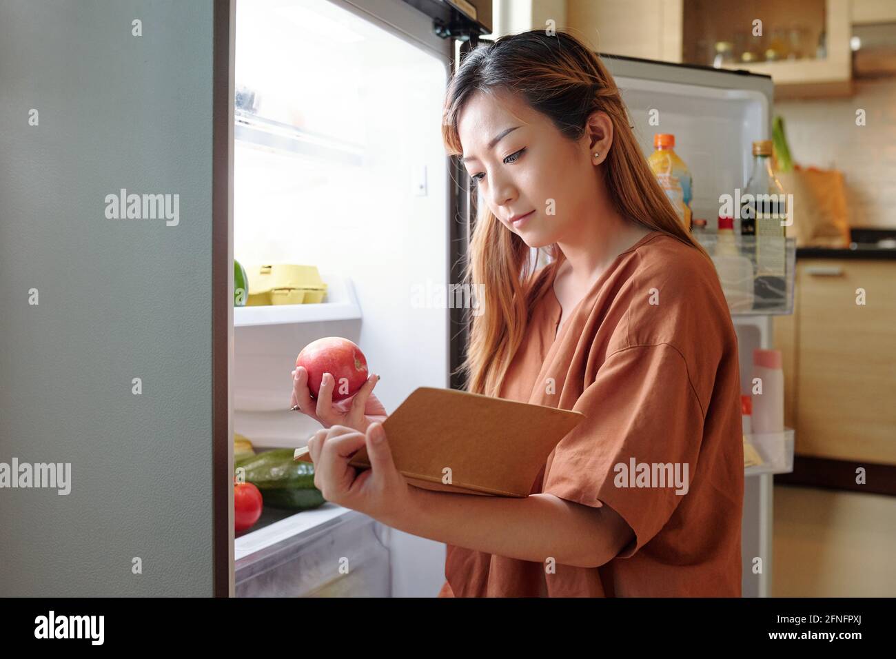Woman checking food in fridge hi-res stock photography and images - Alamy