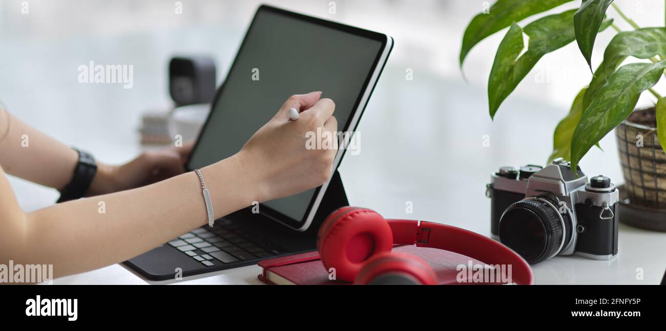 Side view of female hand using mock up tablet with stylus pen on white ...