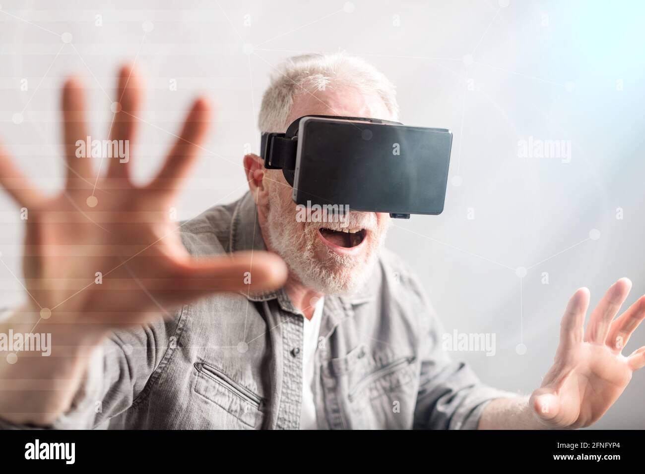 Senior man using a virtual reality headset, double exposure Stock Photo ...