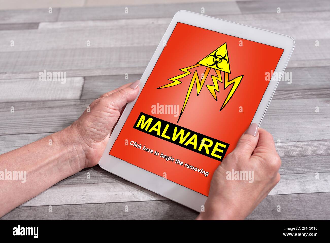 Female hands holding a tablet with malware concept Stock Photo - Alamy