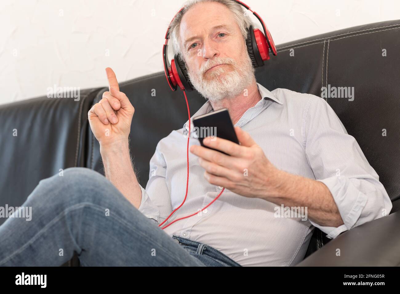 Modern mature man listening music on mobile phone at home Stock Photo ...