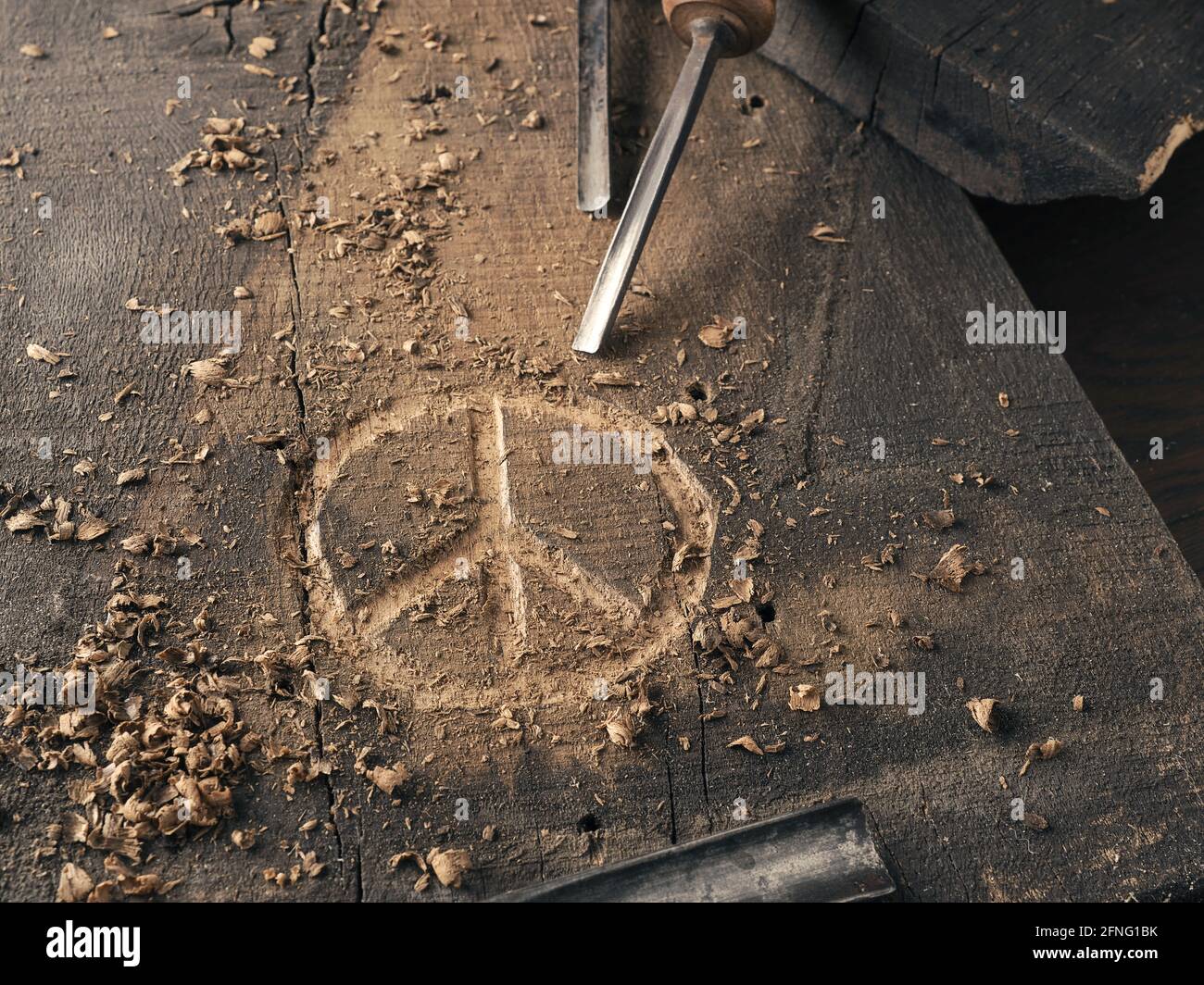 The peace symbol carved in wood with chisels. Peace concept, global ...