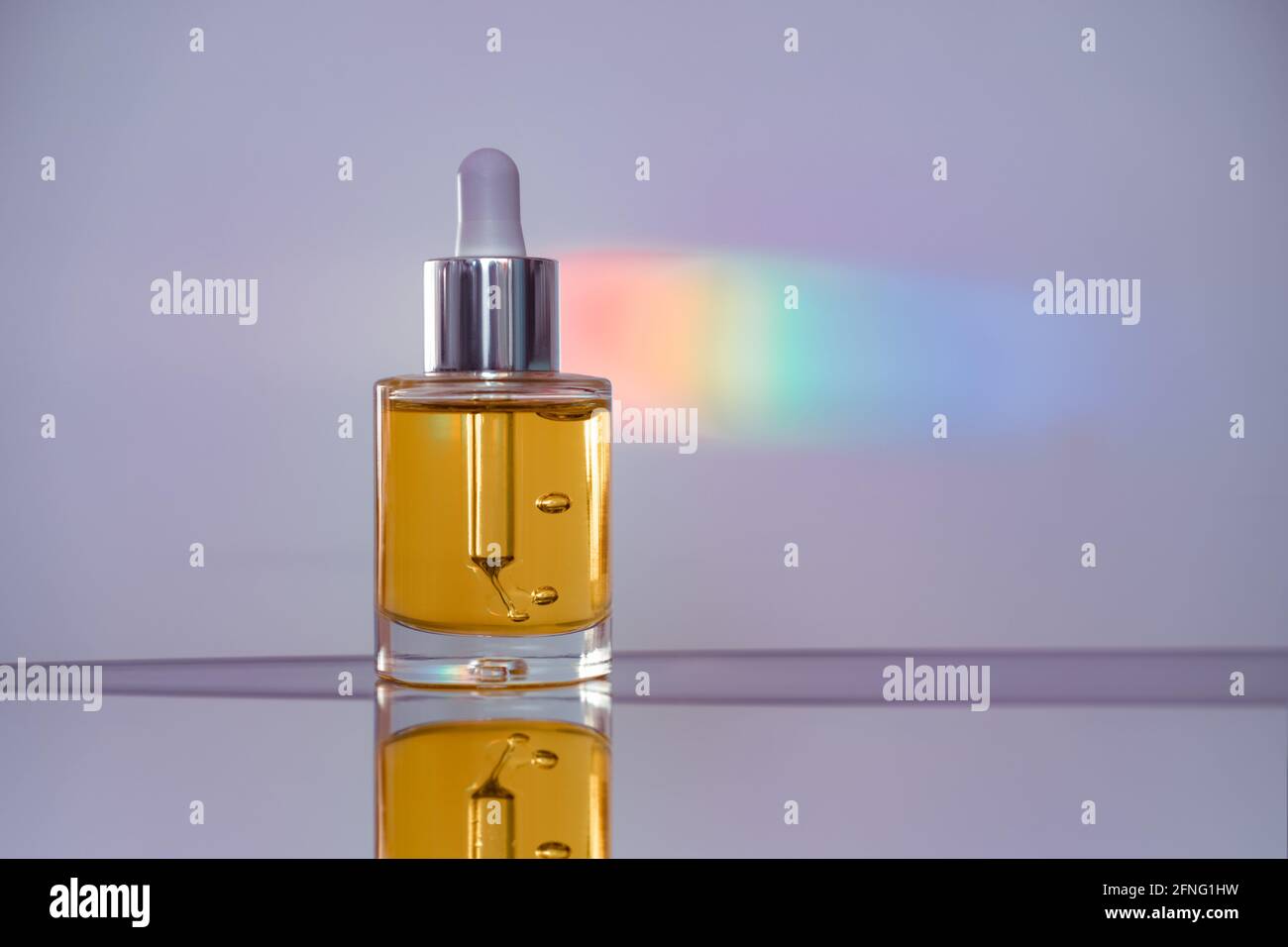 Face oil on reflective surface with a rainbow streak and bubbbles Stock ...