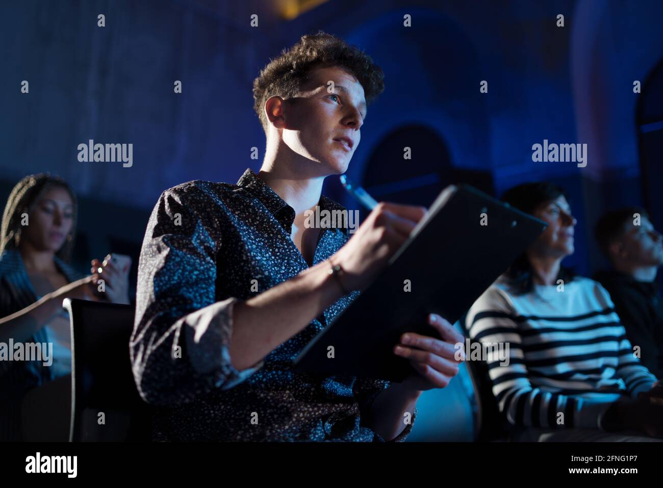 Group of people making notes while listening to presentation at ...