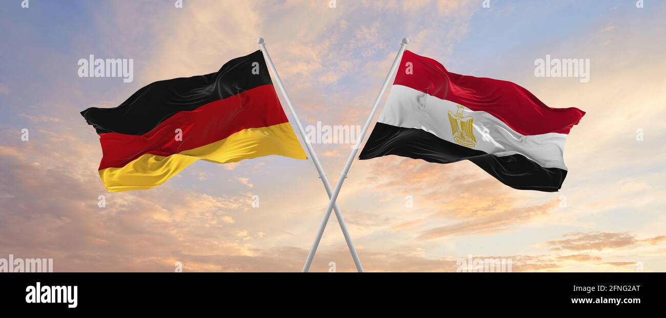 flags of Germany and Egypt waving in the wind on flagpoles against sky ...