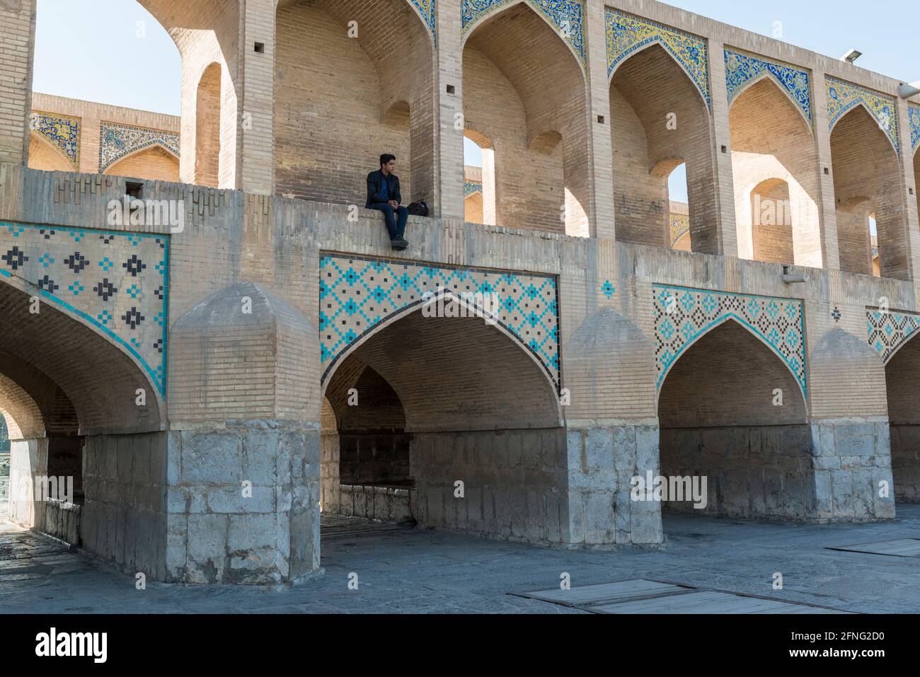 Relaxing man on the historic Khaju bridge over the Zayanderud river in ...