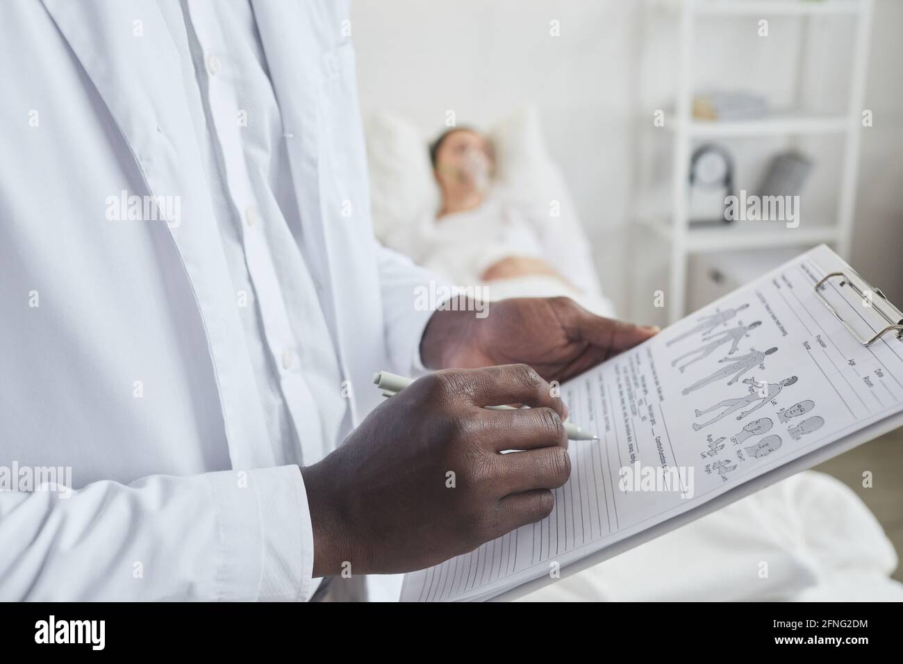 Close-up of African doctor writing prescription in medical card for ...