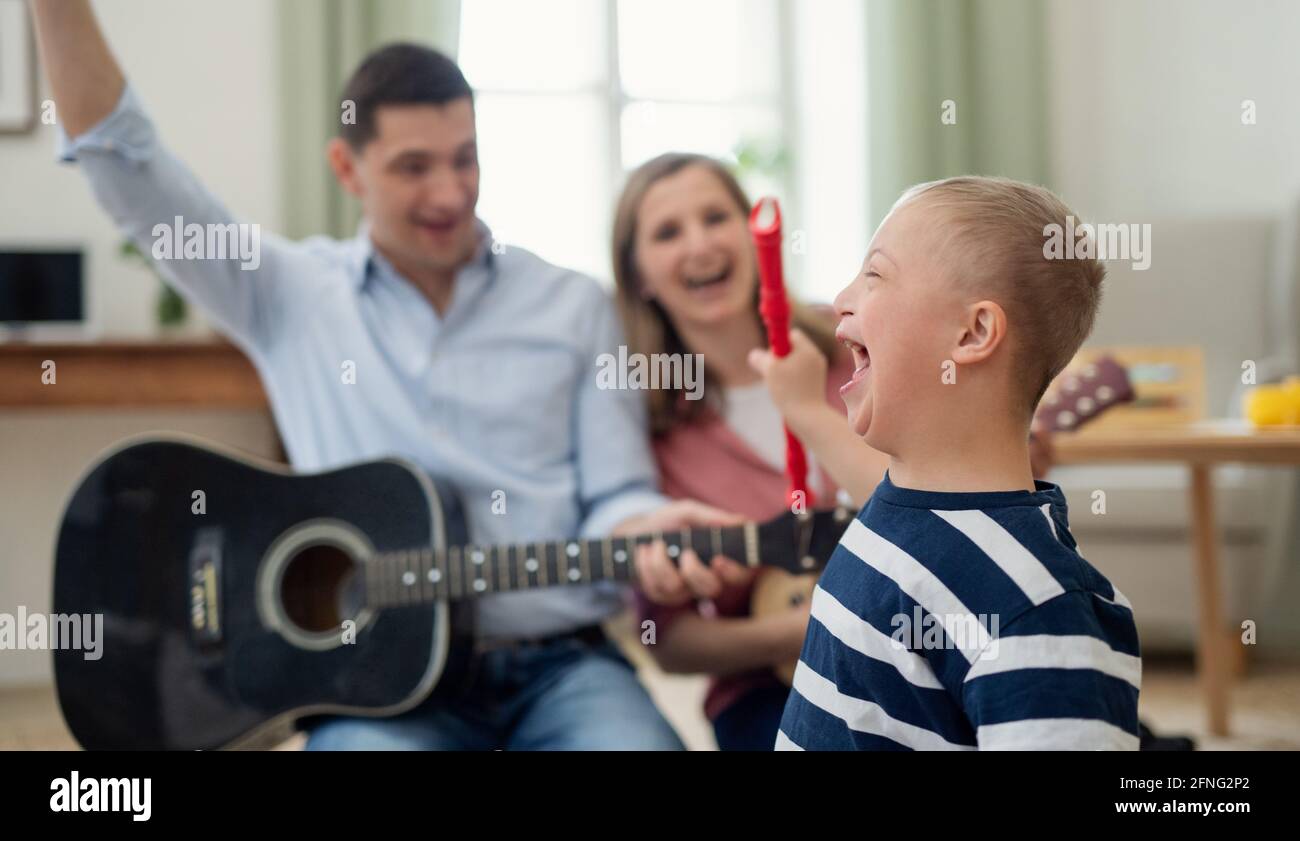 Cheerful down syndrome boy with parents playing musical instruments ...