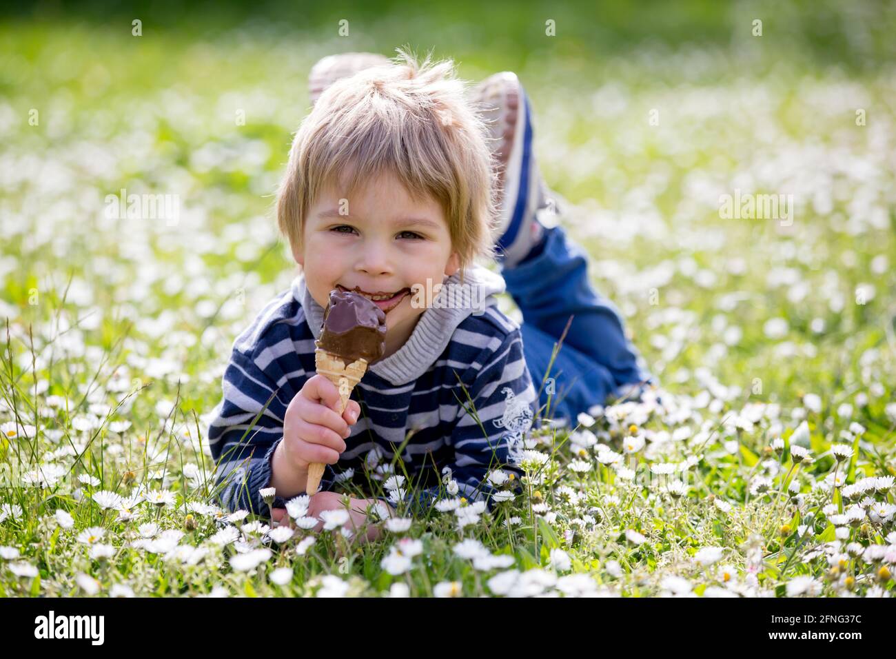 Cute blond child, boy, eating ice cream in the park, springtime Stock ...