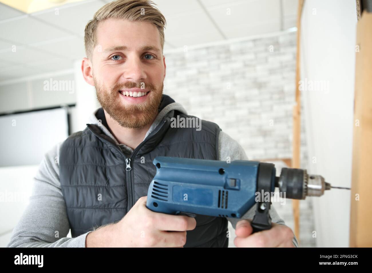 man drilling the wall with drill perforator Stock Photo - Alamy
