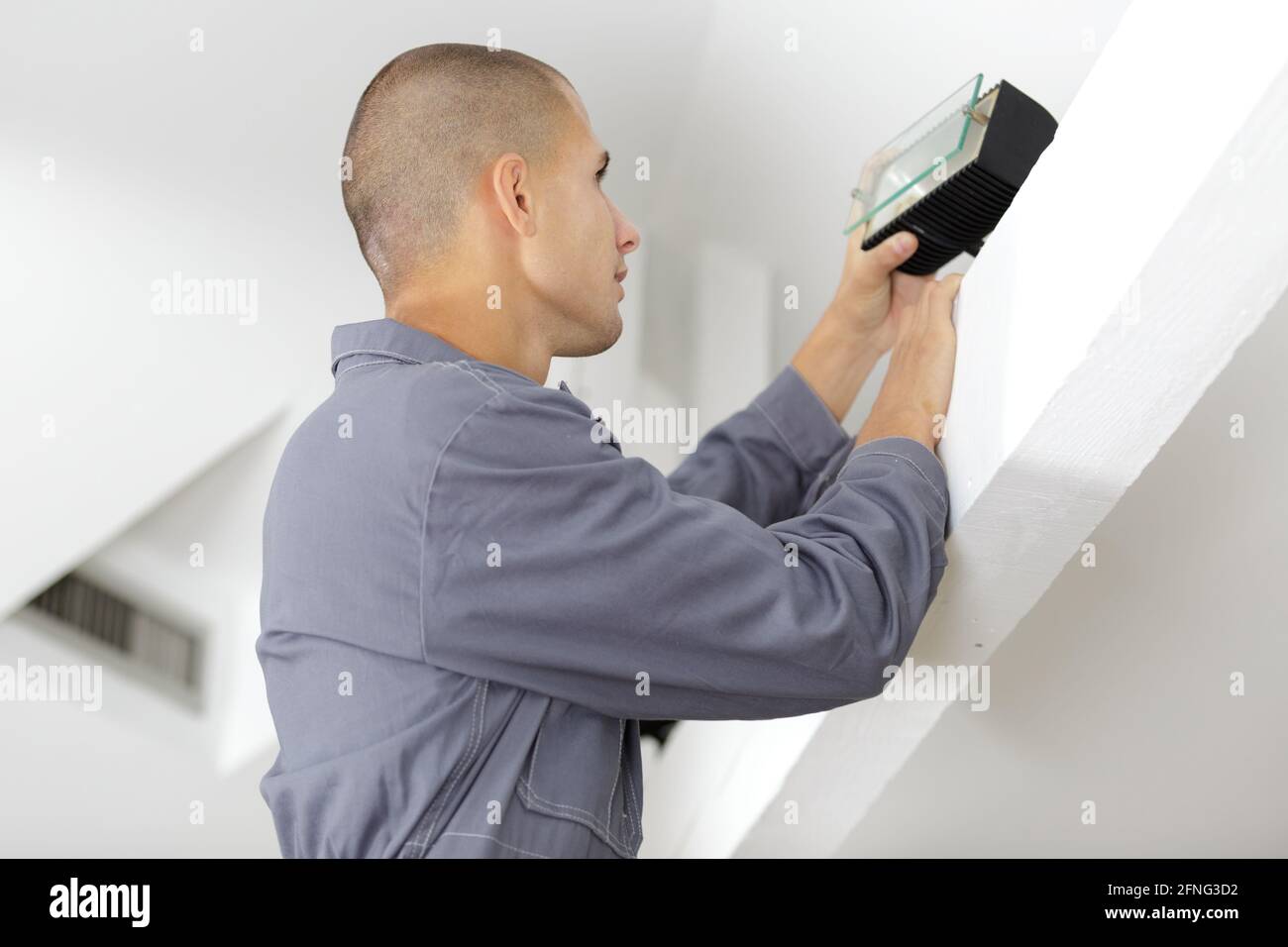 young electrician installing ceiling light Stock Photo - Alamy