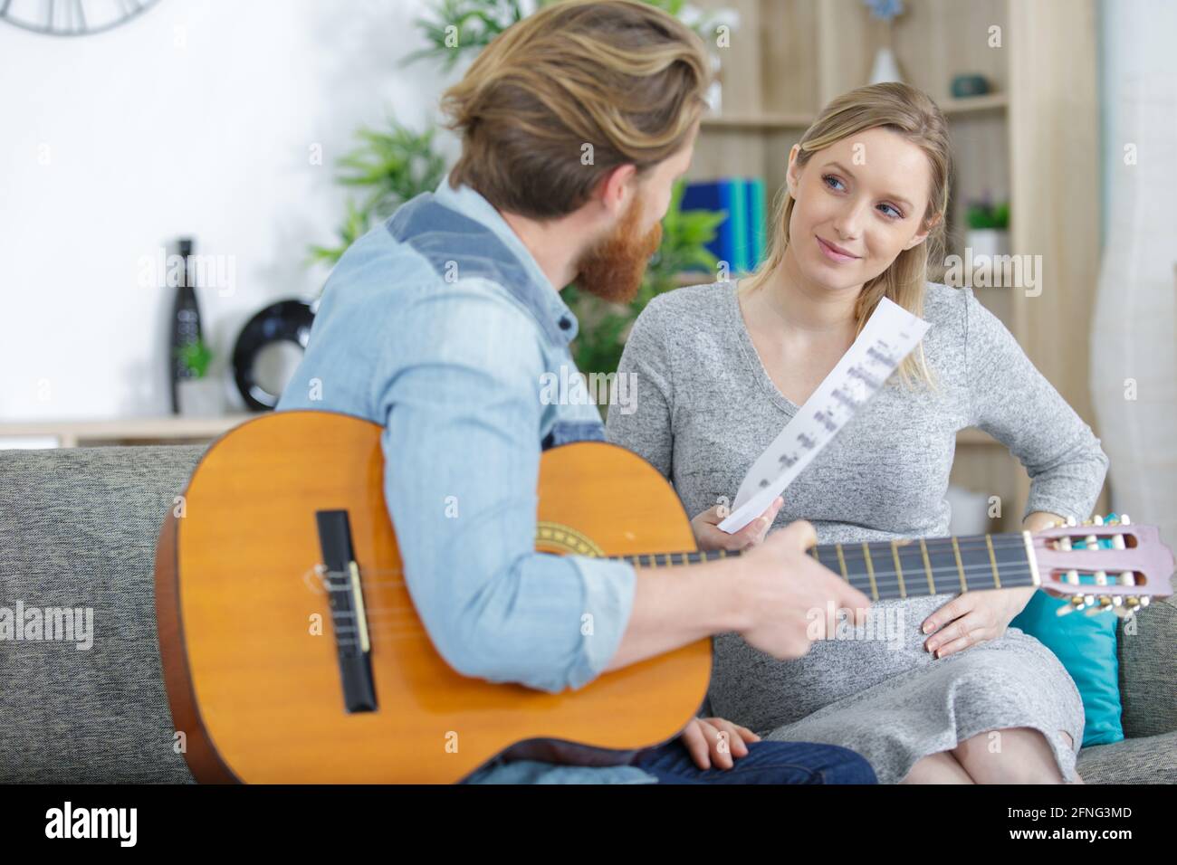 Couple playing acoustic guitar hi-res stock photography and images - Alamy
