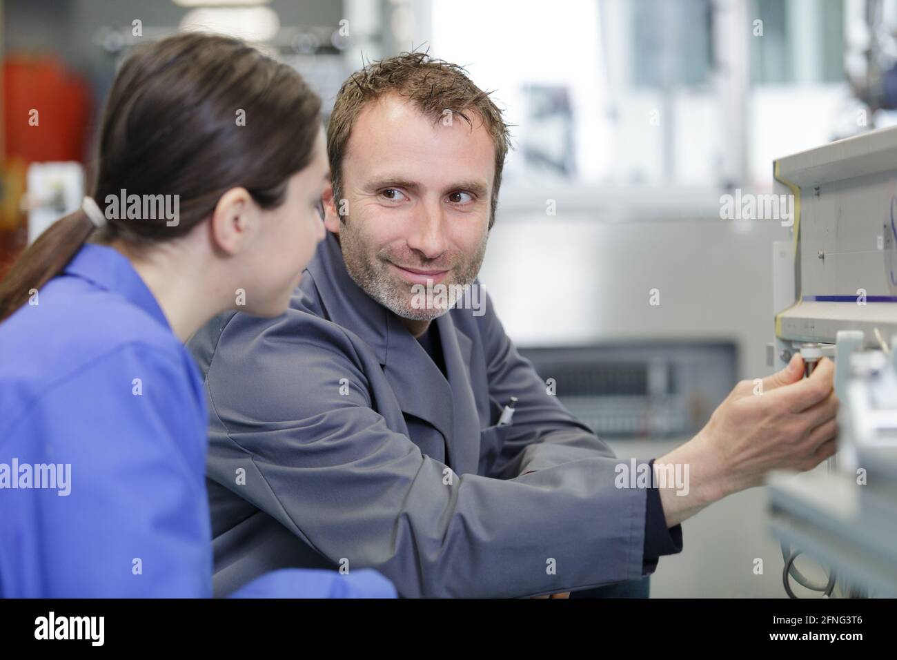 engineer training female apprentice on milling machine Stock Photo - Alamy