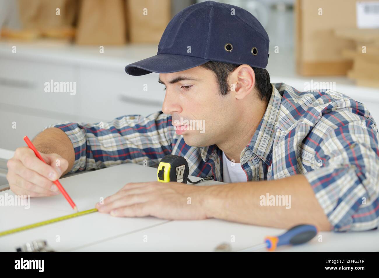man measuring wood with tape measure Stock Photo - Alamy