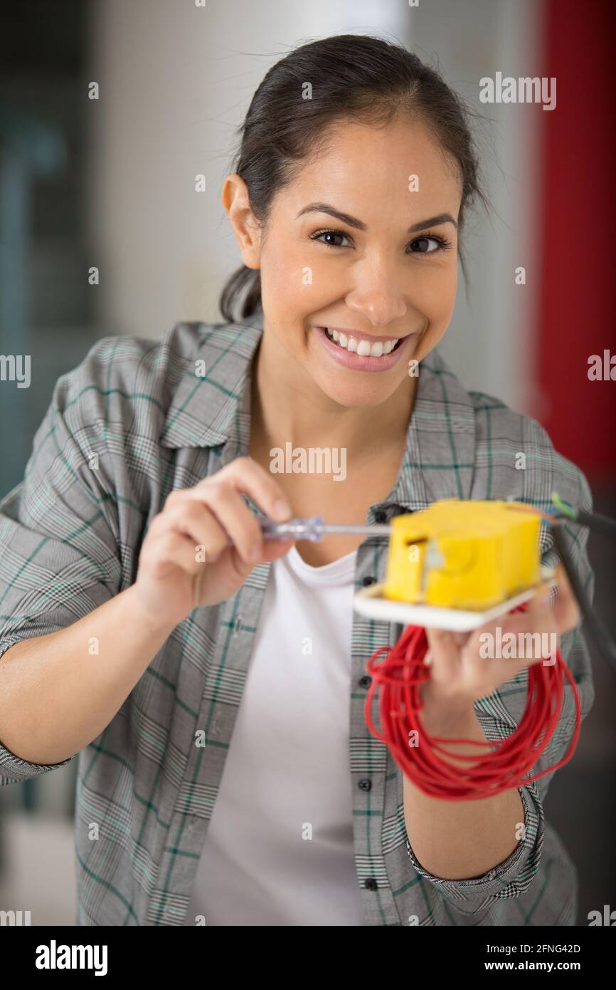 female electrician holding a electrical box Stock Photo - Alamy