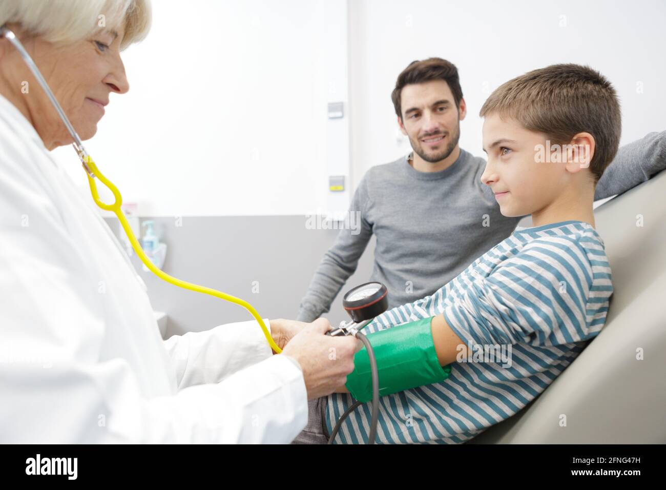 senior female doctor taking pulse of the kid Stock Photo - Alamy