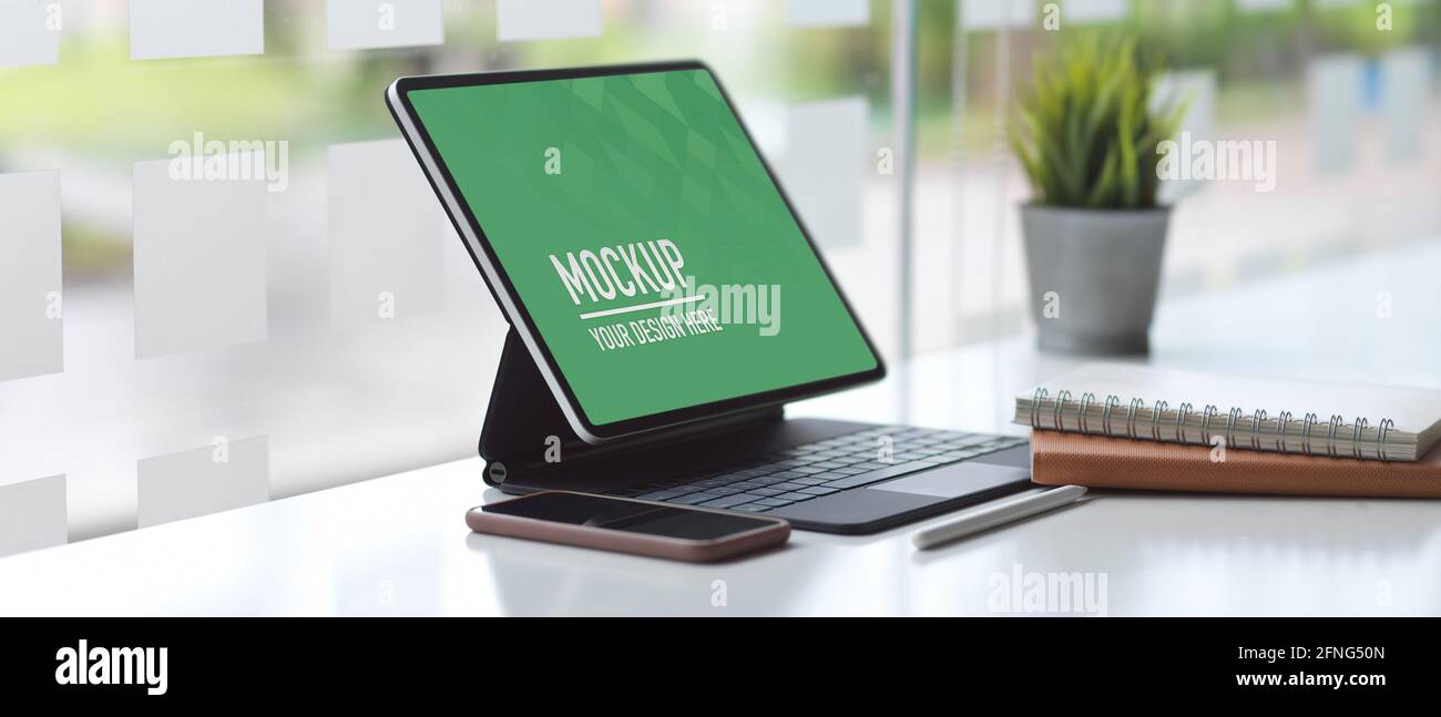 Side view of worktable with clipping path tablet, keyboard, smartphone ...