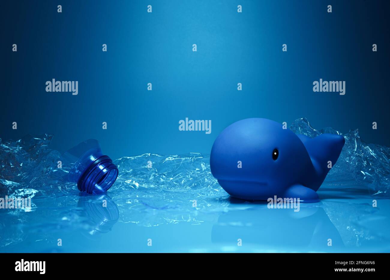 Arrangement of blue toy dolphin wrapped in plastic debris representing ...