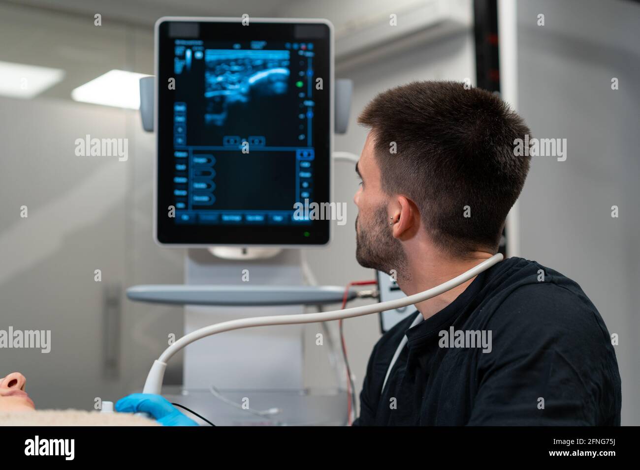 Male doctor checking up chest of Woman on monitor of ultrasound machine ...