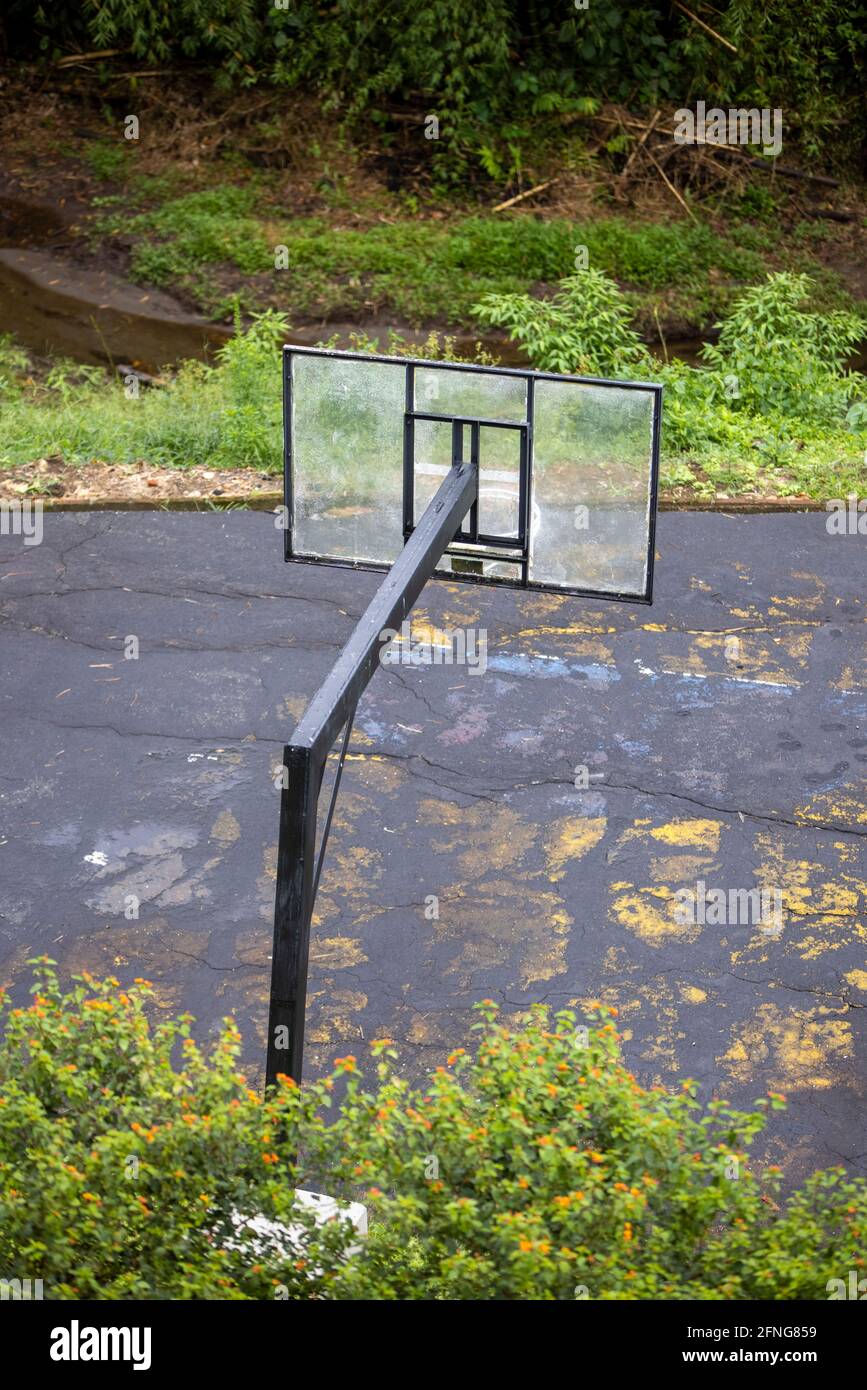 Basketball hoop with basket placed on asphalt sports ground surrounded ...