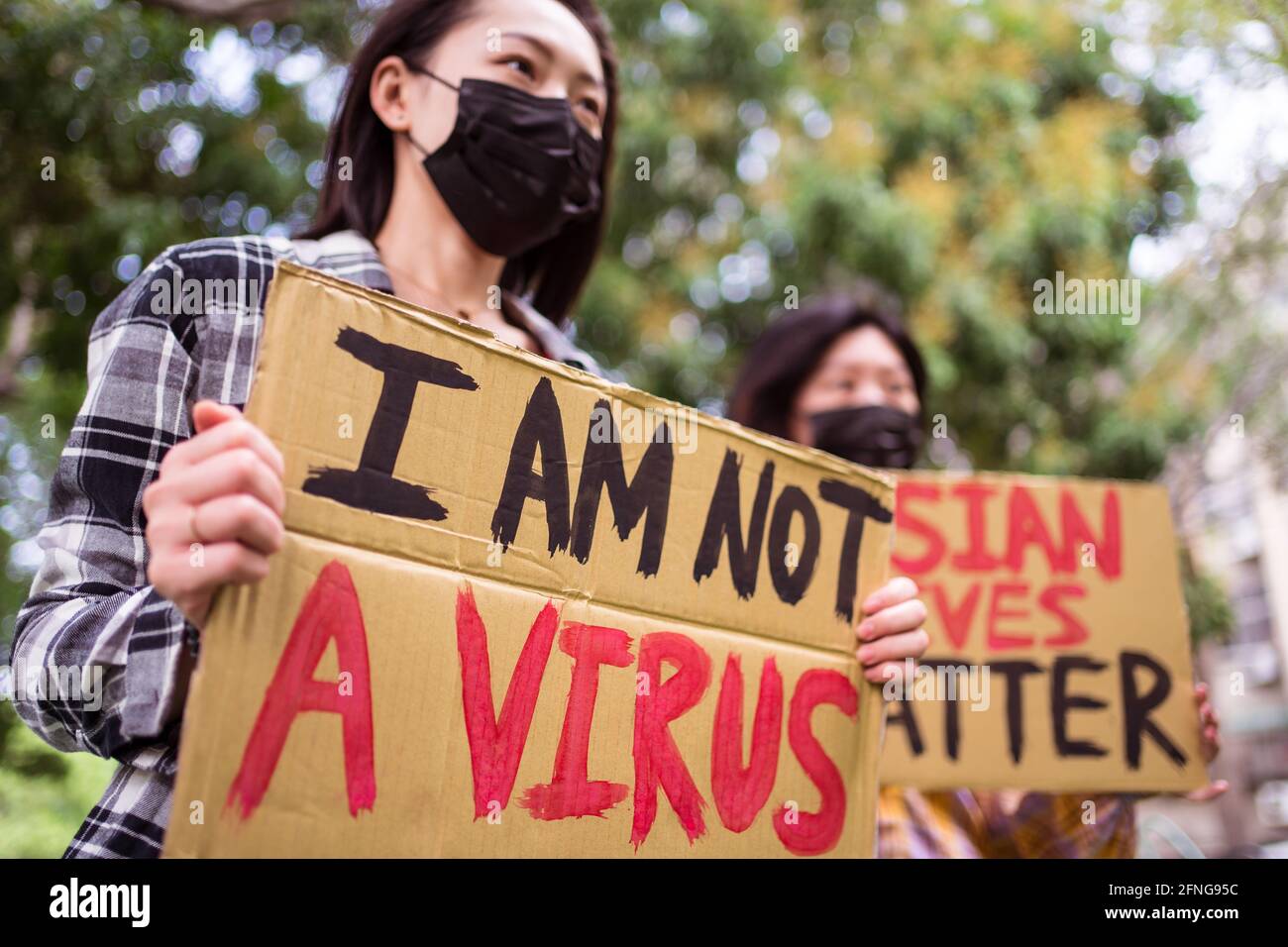 Ethnic females in masks holding posters protesting against racism in ...