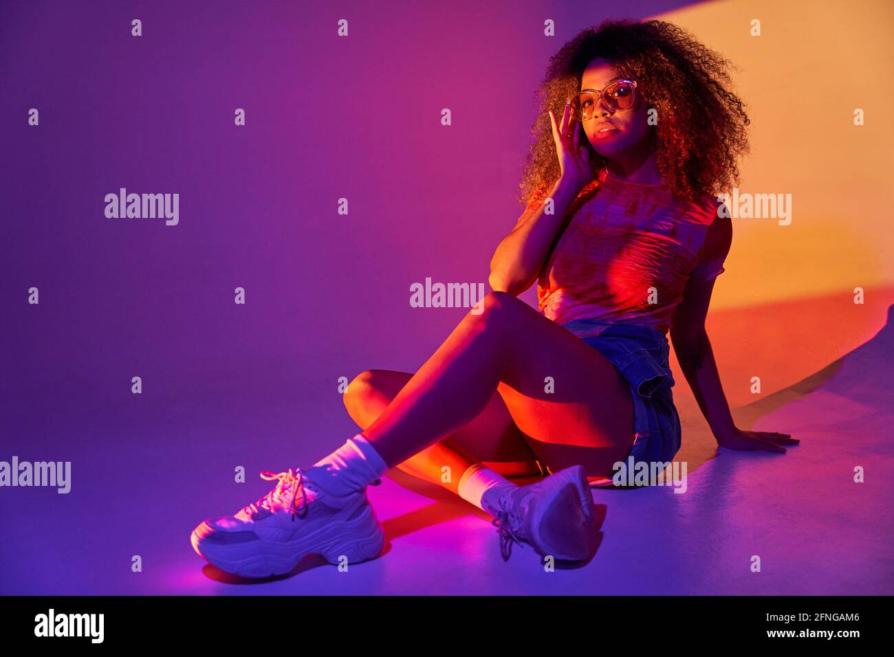 Baker standing at counter with fresh bread buns placed on baking pan in ...