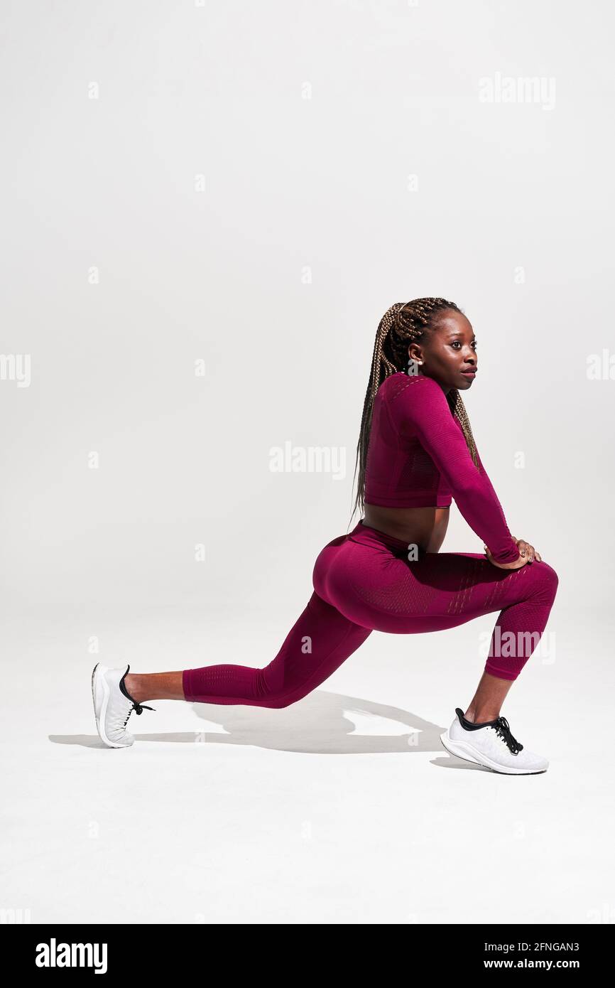 Black sportsWoman in activewear training on white background Stock ...