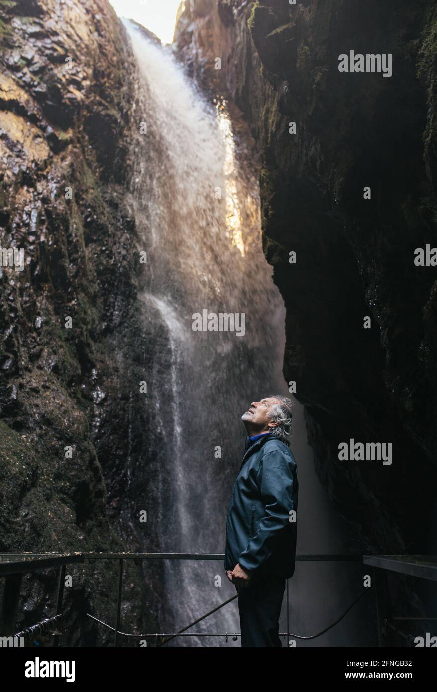 Side view of aged man with gray hair standing on observation balcony ...