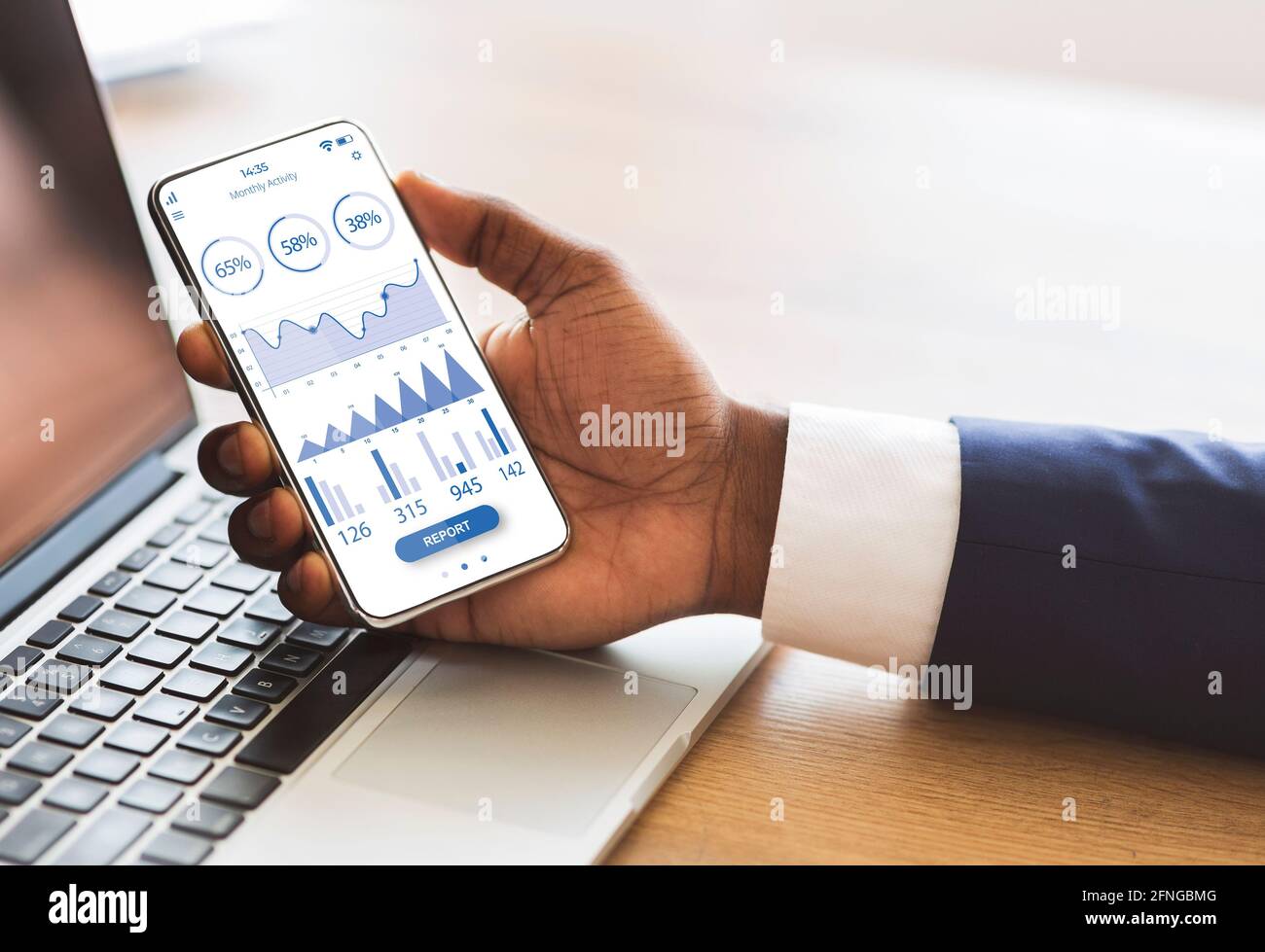 Black manager using mobile phone with trading app Stock Photo - Alamy