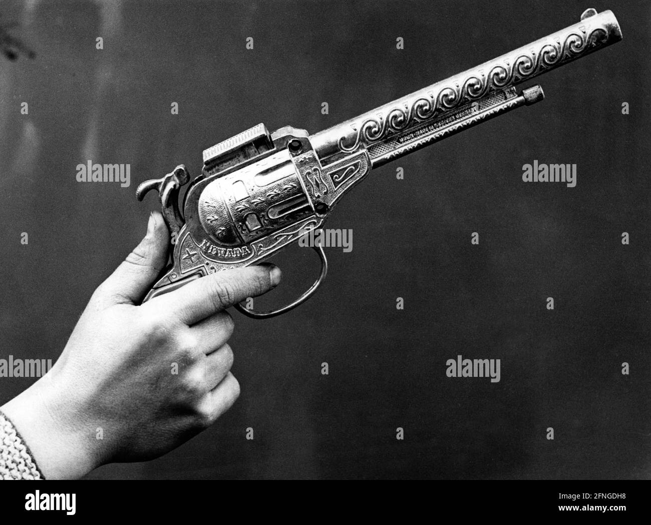 Child's hand holding toy gun, 60s [automated translation] Stock Photo ...