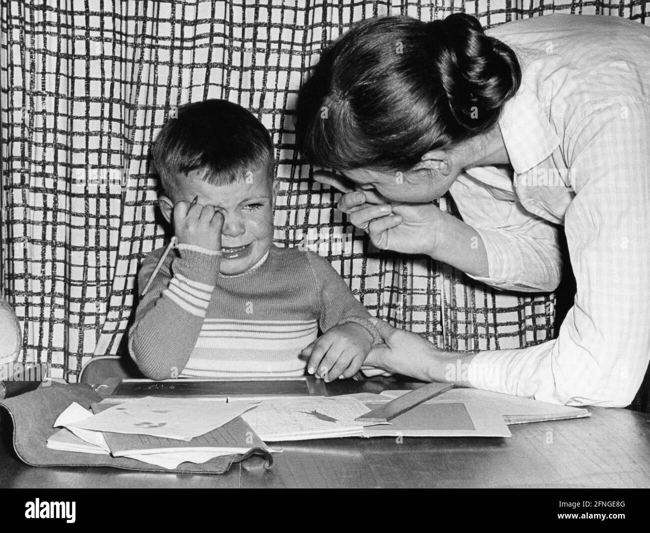 A boy cries because his mother scolds him about the messy school ...