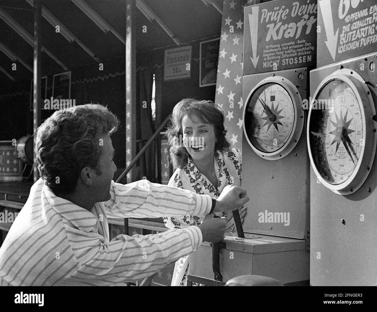 Man impresses a lady by showing off his power at a fairground vending ...