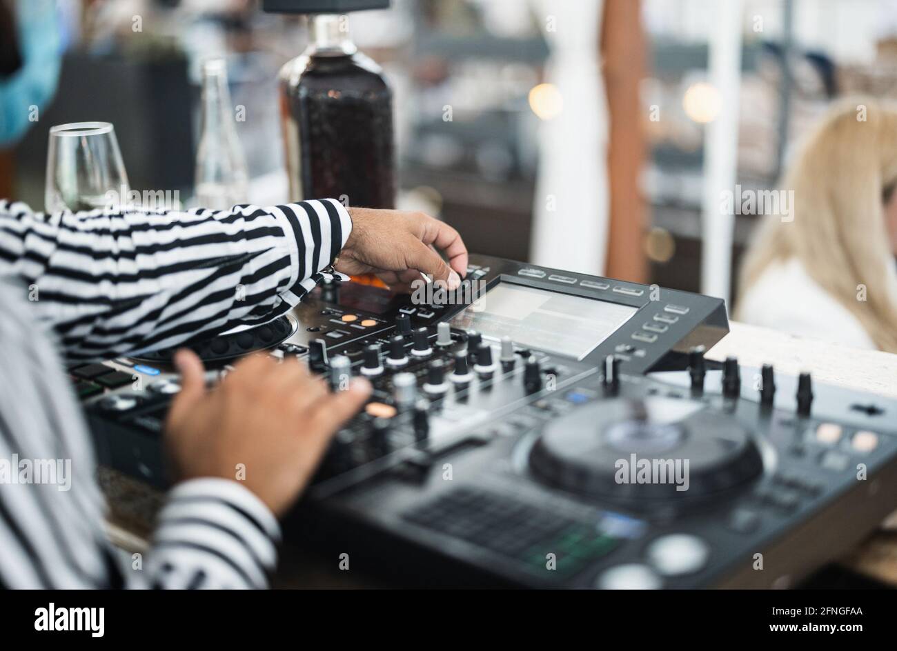 Black Dj playing music at cocktail bar outdoor while wearing face ...