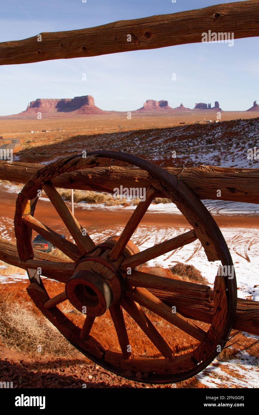 Monument Valley in winter through a wooden fence with stagecoach wheels ...