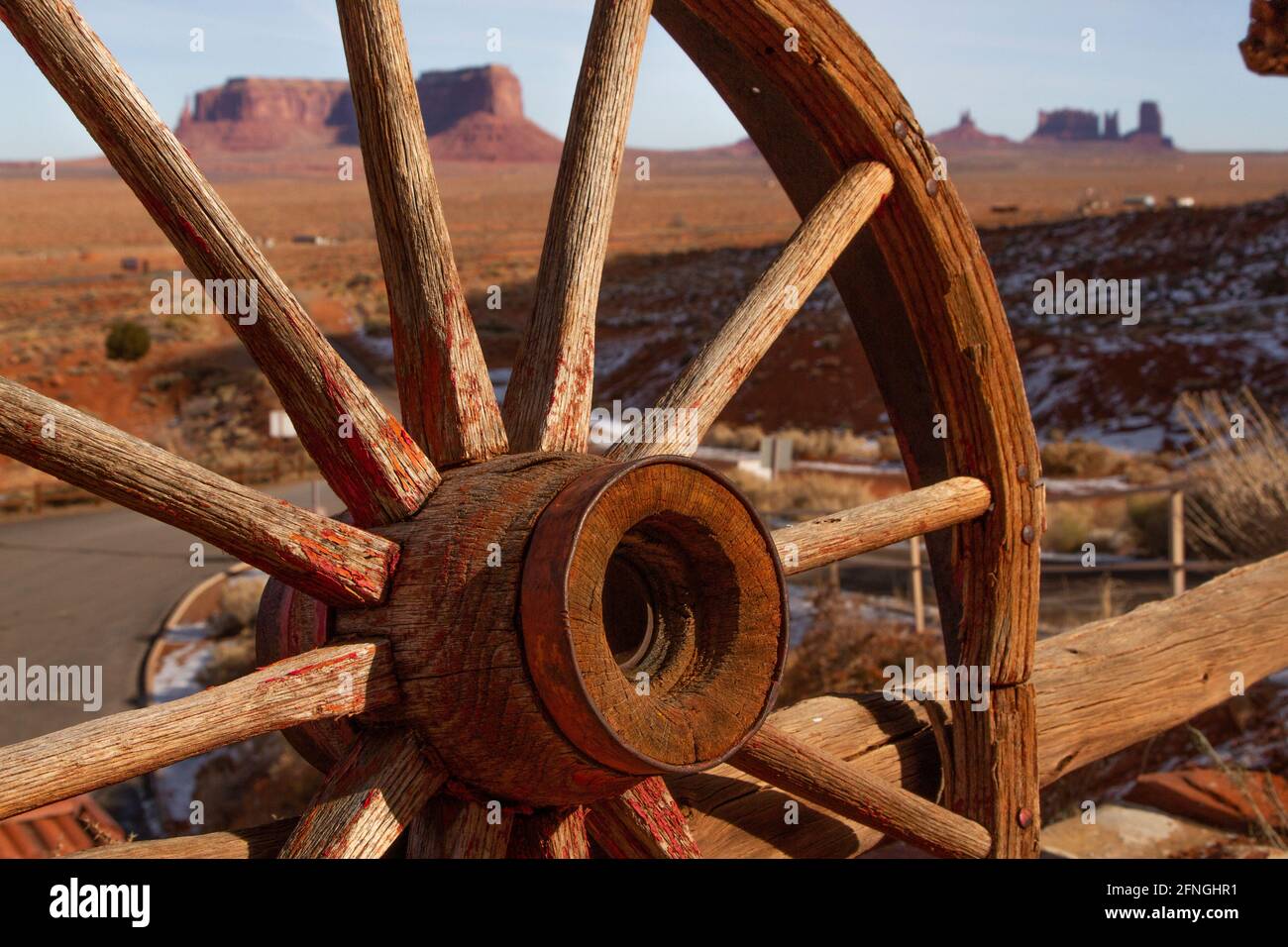 Monument Valley in winter through a wooden fence with stagecoach wheels ...