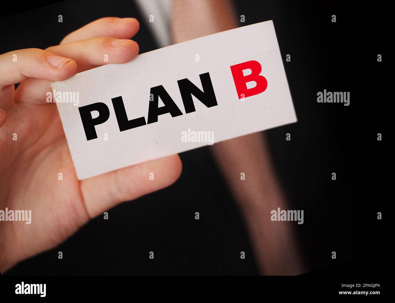 Plan B words on card in hand of businessman wearing suit and tie ...